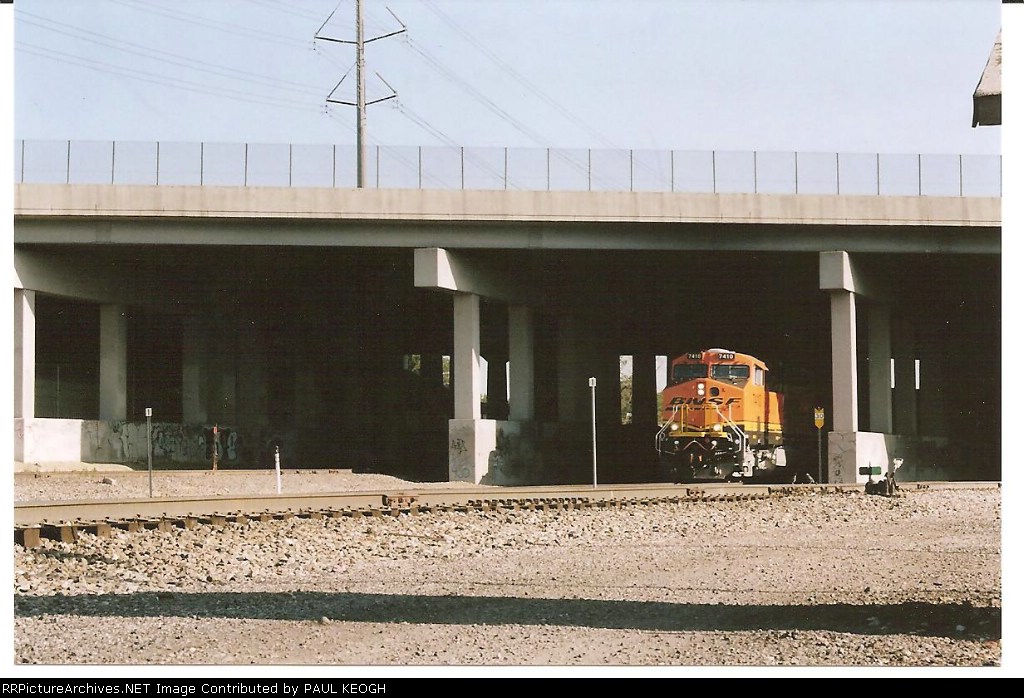 BNSF 7410 emerges from the I-25 overpass as she rolls south to Colorado Springs, Co.